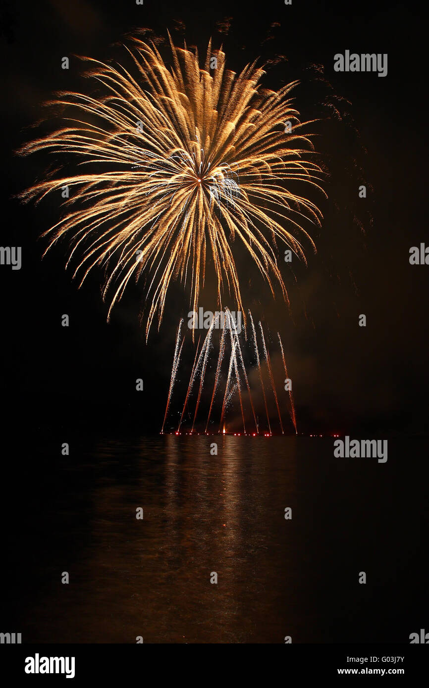 Colorful fireworks with reflection on lake and night sky in background ...