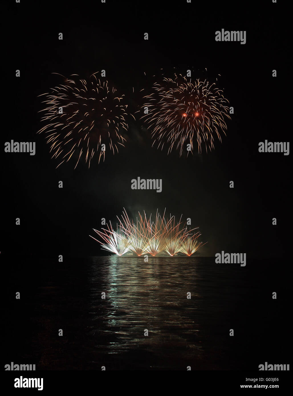 Colorful fireworks with reflection on lake and night sky in background ...