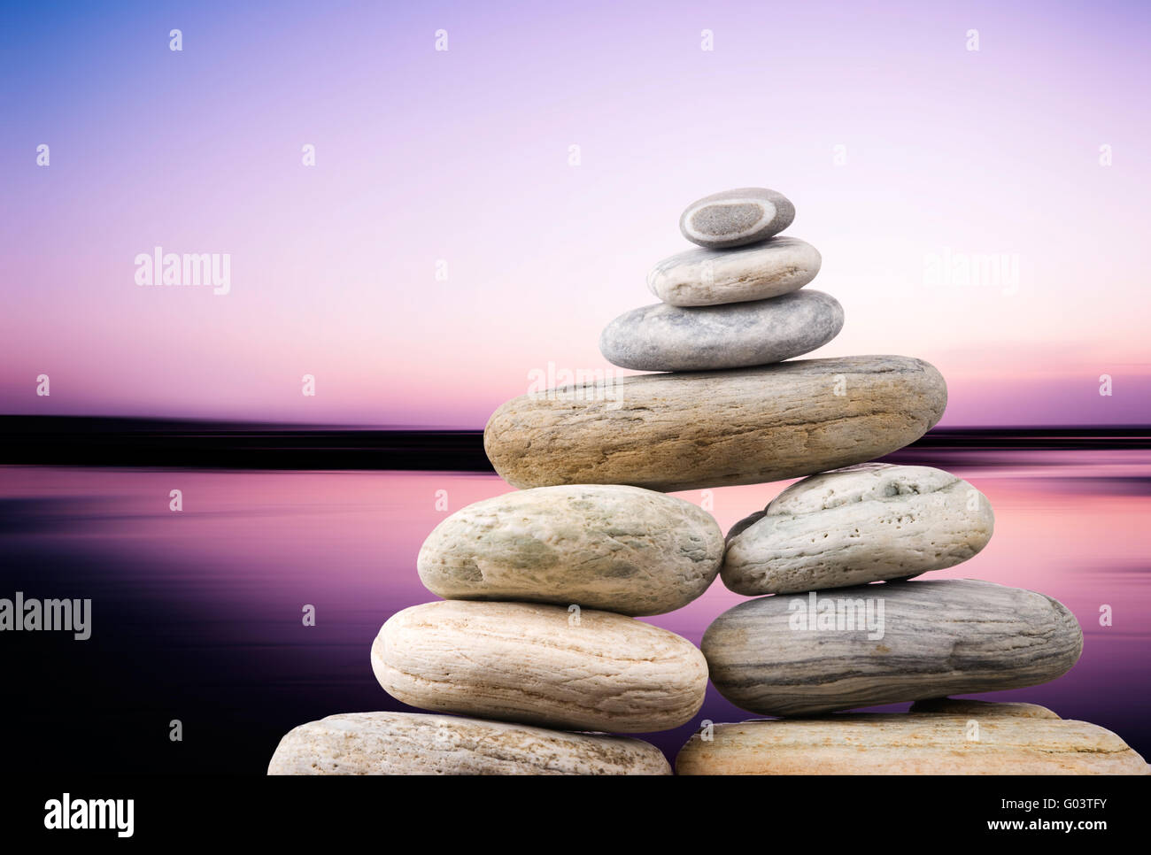Pebbles stack in peaceful evening with smooth ocean background. Zen ...