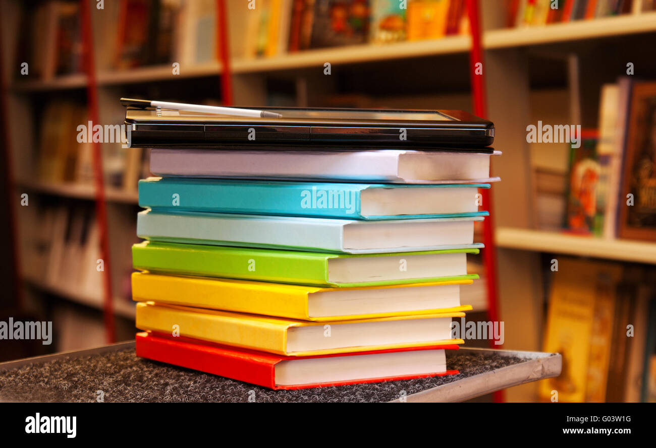 Stack of colorful books with electronic book reade Stock Photo - Alamy
