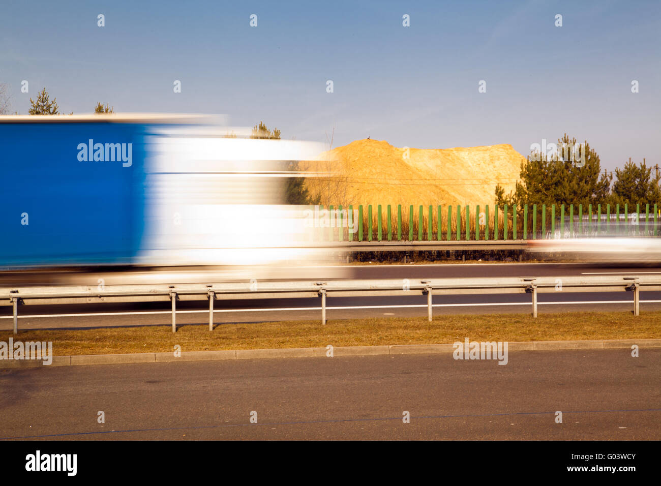 Big rig passing the highway with motion blur Stock Photo - Alamy