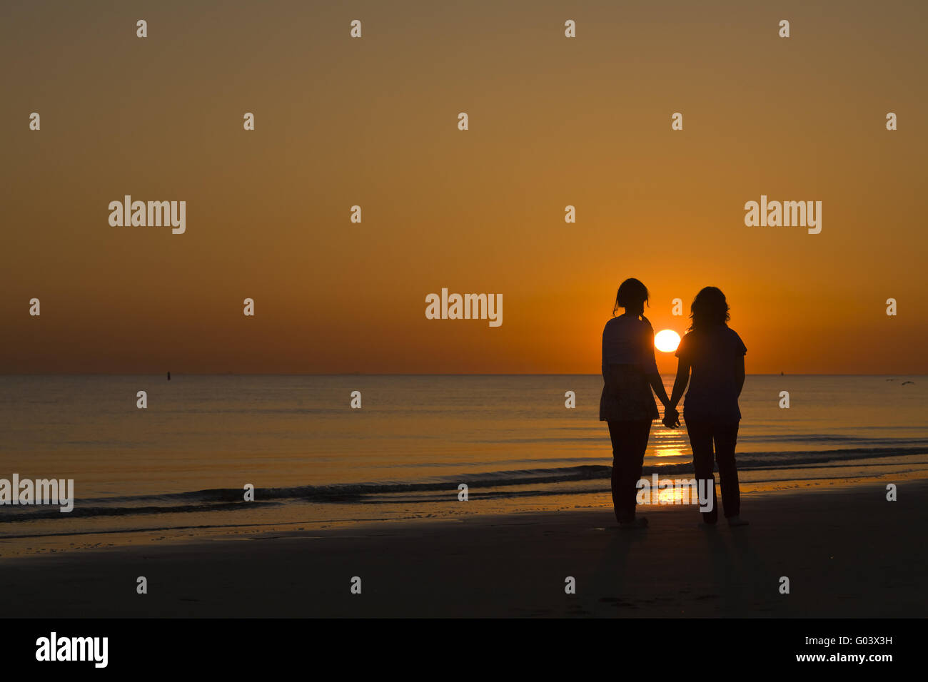 Friends at sunset Stock Photo - Alamy