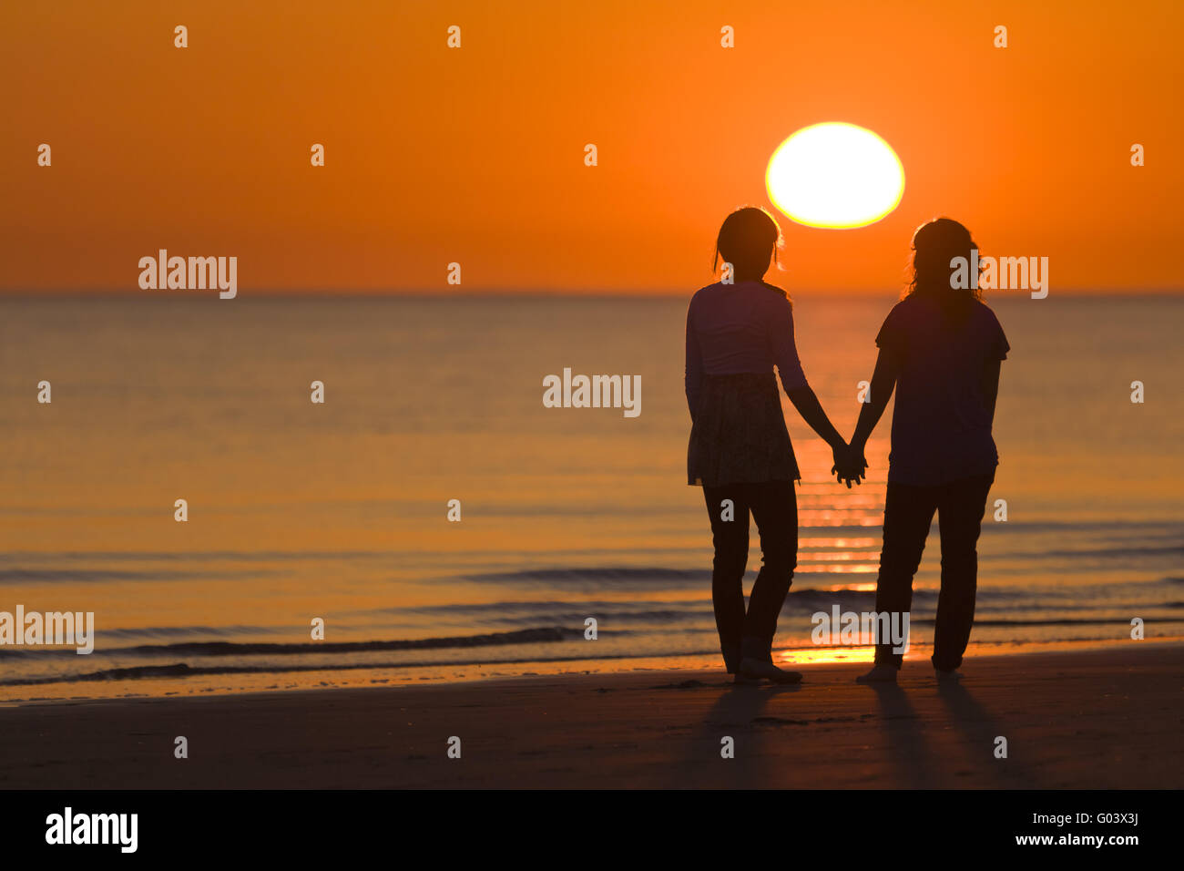 Friends at sunset Stock Photo - Alamy