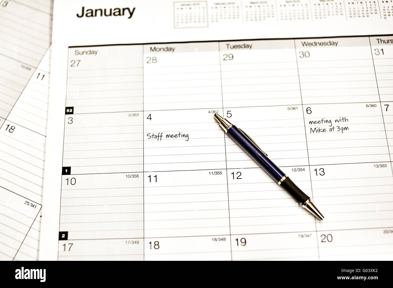 Desktop planner with a pen and scheduled appointments with shallow ...