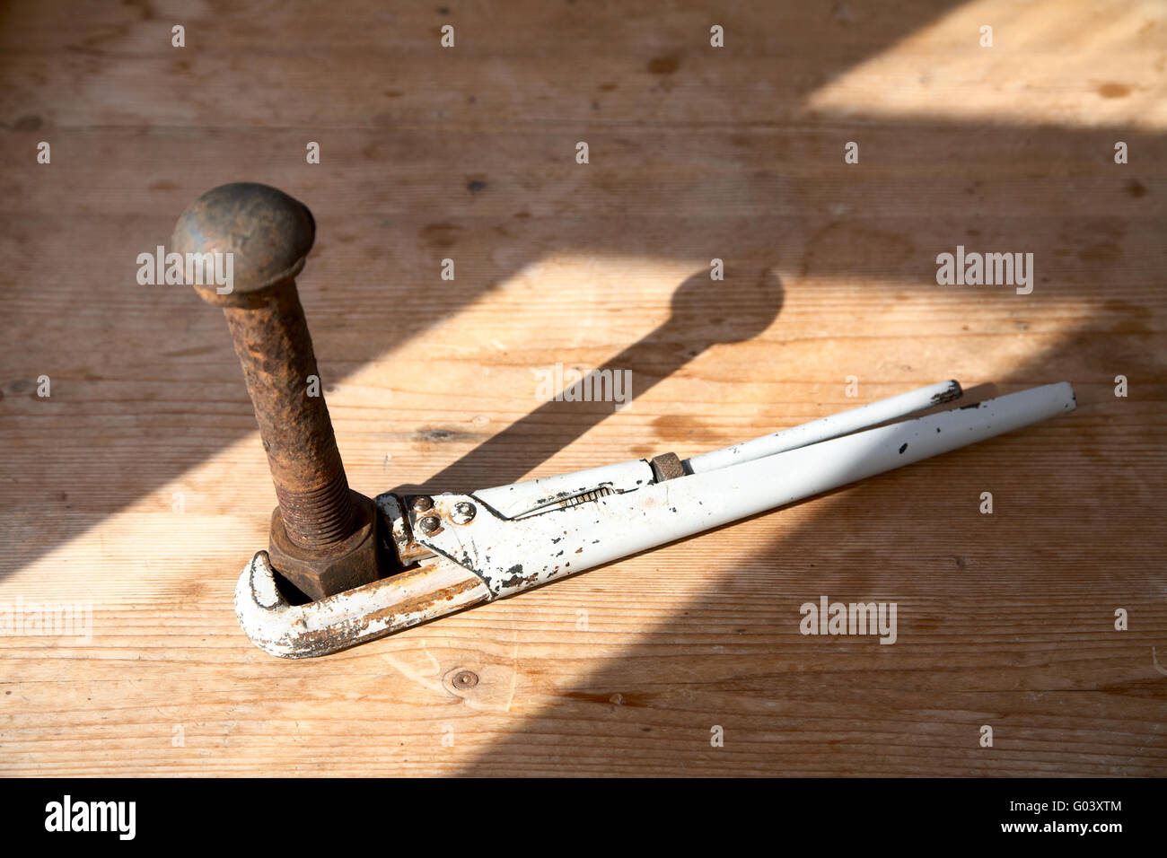Adjustable spanner and rusty bolt with a nut on table Stock Photo - Alamy