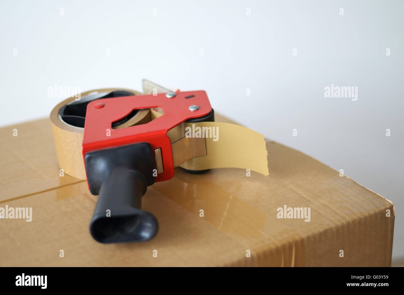 Self-adhesive tape dispenser on brown cardboard box Stock Photo - Alamy