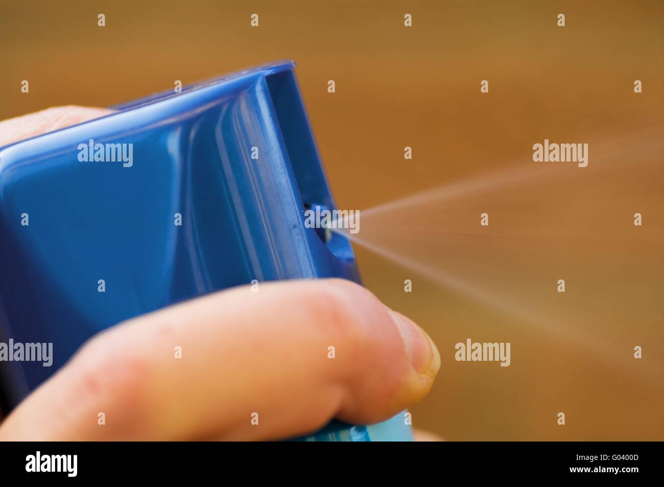 Finger presses the button and the spray can sprays Stock Photo - Alamy