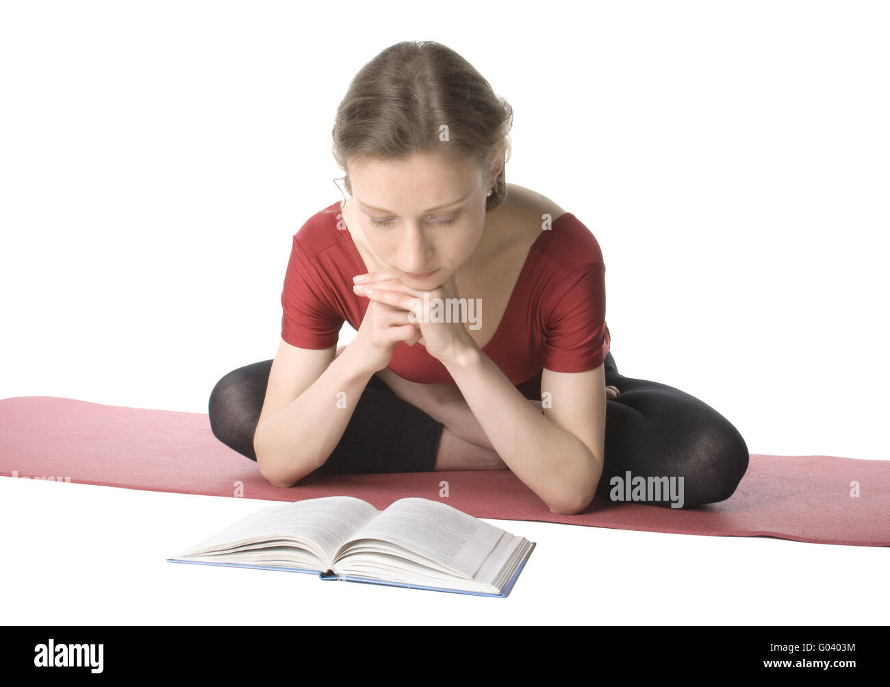 Young woman reading a book sitting in a lotus pose Stock Photo - Alamy