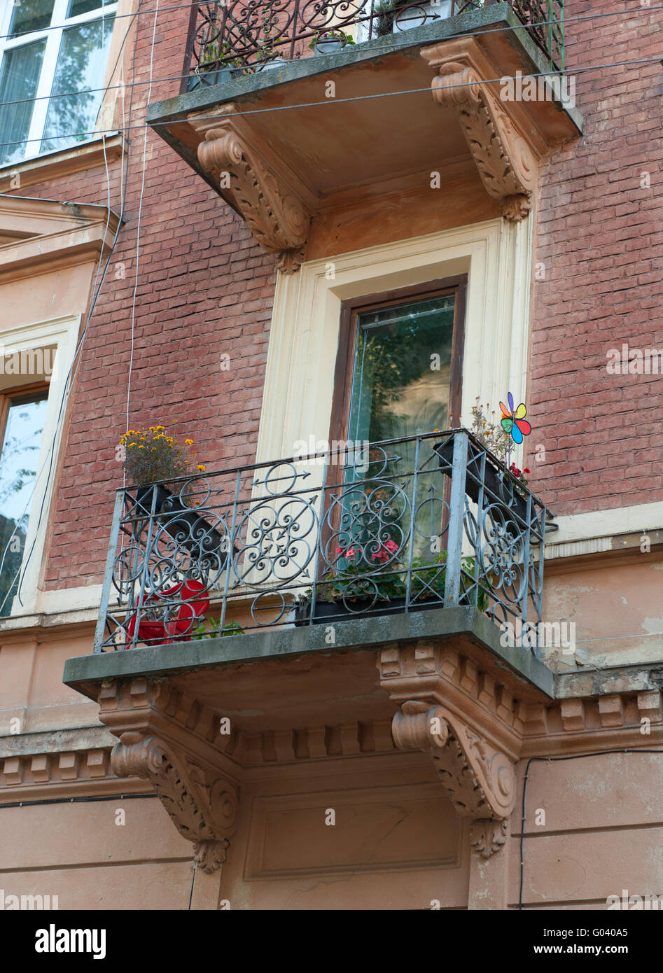 Facade of a building with a balcony and flowers Stock Photo - Alamy