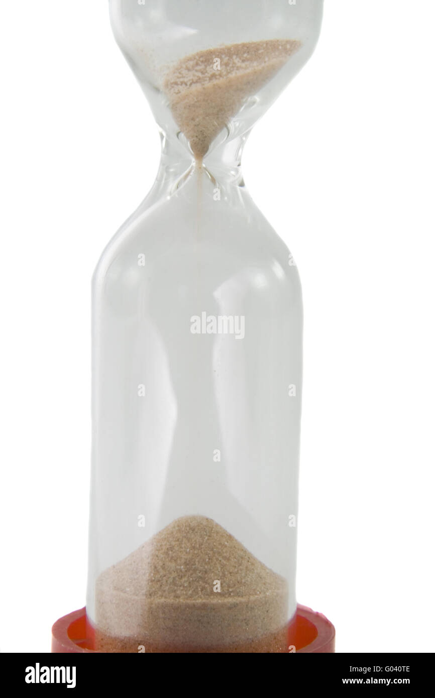 Closeup view of sand flowing through an hourglass isolated over white ...