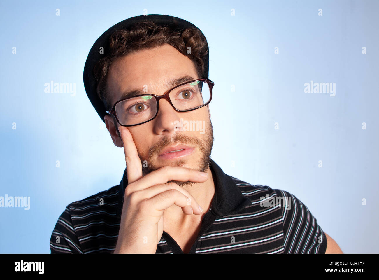 Young man modern nerd thinking wide angle portrait blue background ...