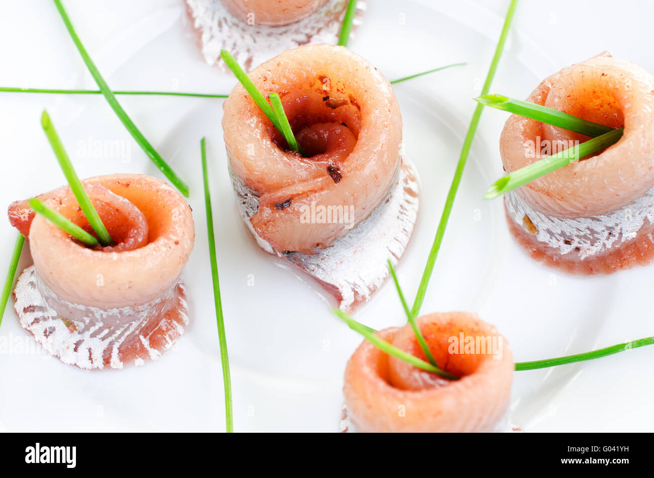 Rolls of marinated herring close up with spring onion Stock Photo - Alamy