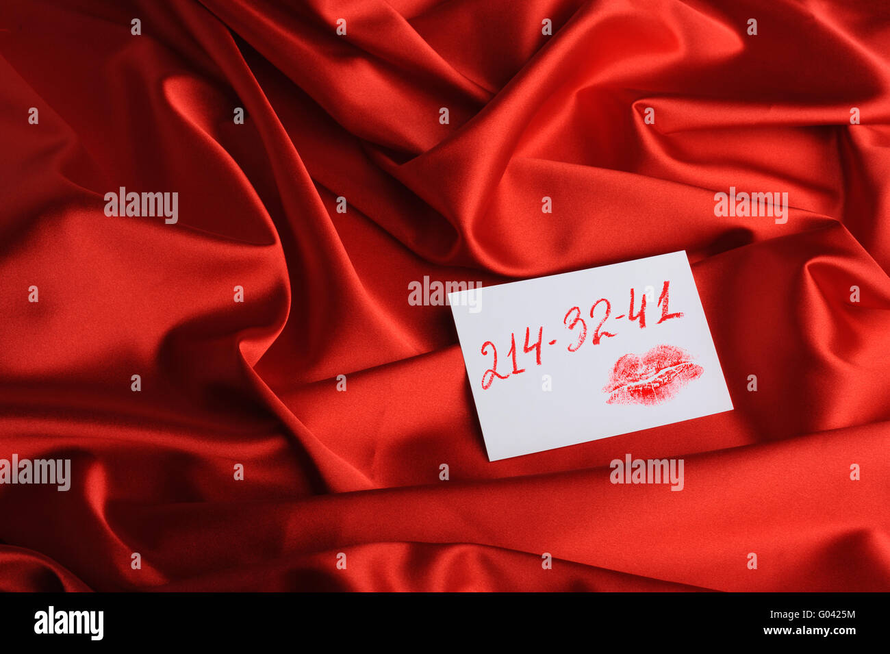 Note on red silk. With an invented phone number and a print of lips ...
