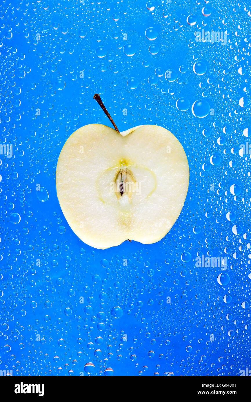 Apple segment on blue background with water drople Stock Photo - Alamy