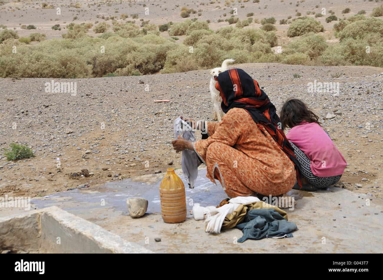Nomad woman in de Moroccan desert wash laundry Stock Photo - Alamy