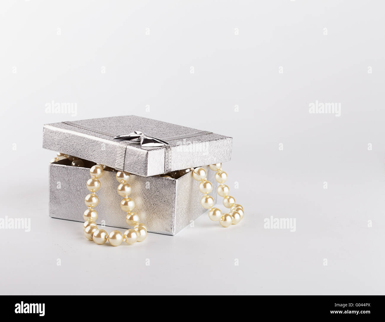 silver gift box with string of pearls on white background Stock Photo ...