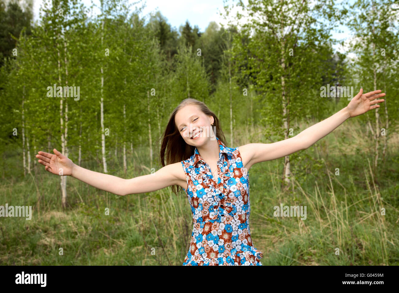 girl has widely stretched hands against young birches Stock Photo - Alamy