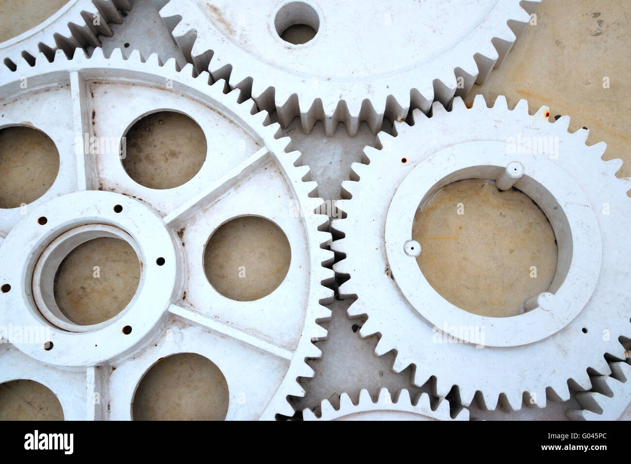 set of big industrial metallic gears on the concre Stock Photo - Alamy