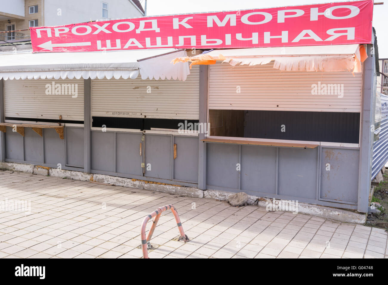 Closed trade pavilions with a banner, a passage to the sea and barbecue ...