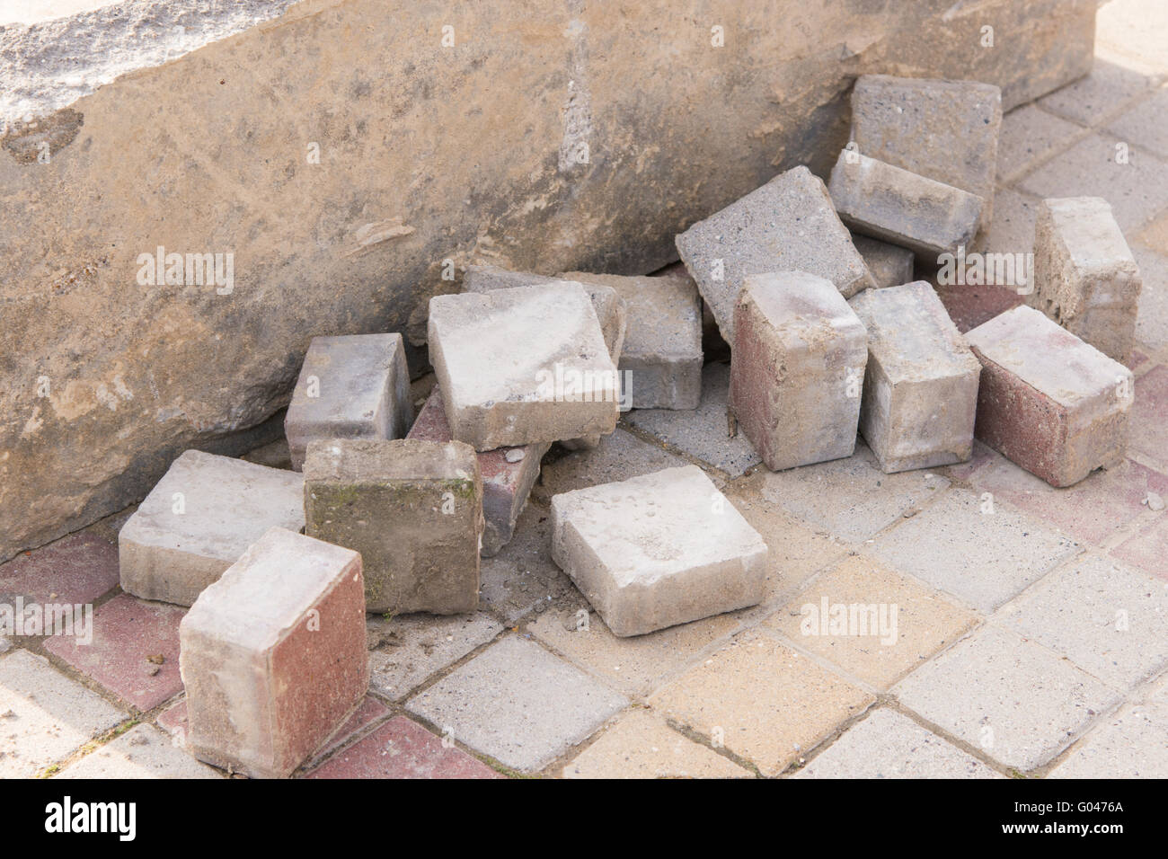 Pieces of old paving slabs lie in a concrete block on the pavement ...