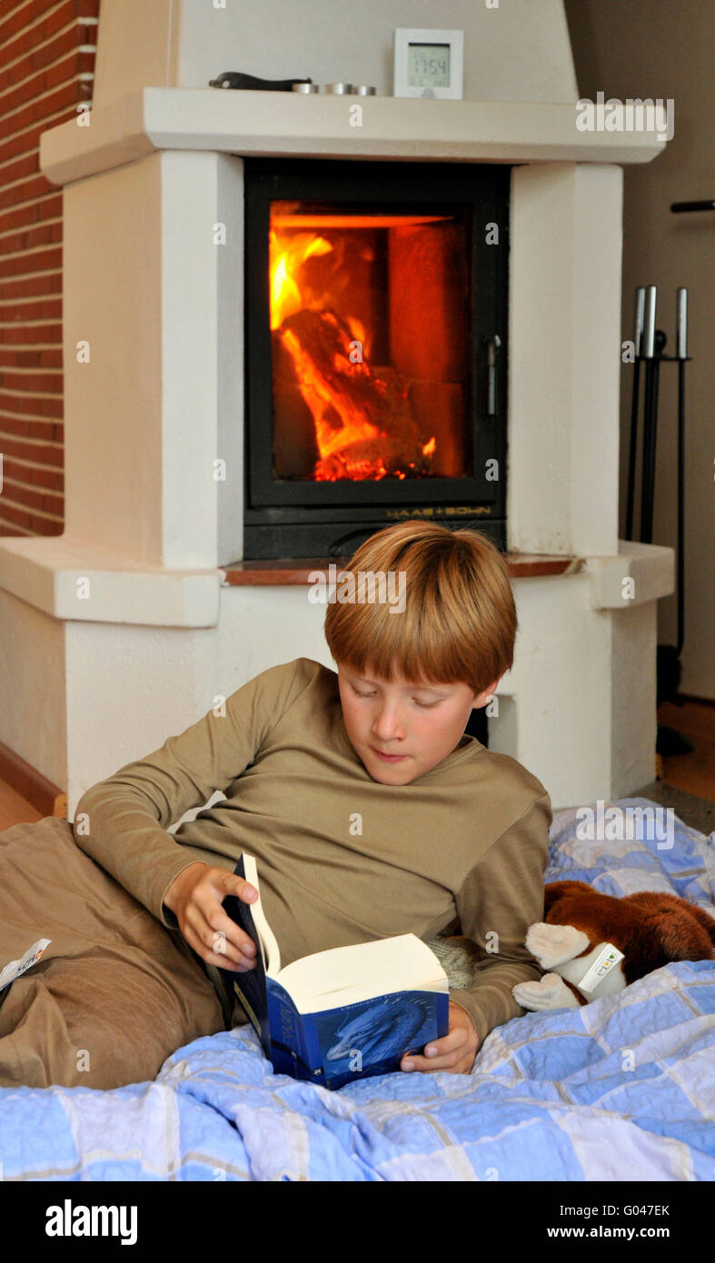 Boy, reading book, fireplace, blanket Stock Photo - Alamy