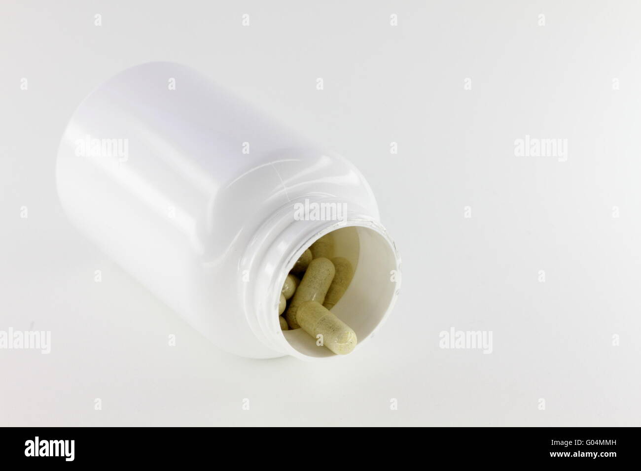 Spilled capsules from white prescription container Stock Photo - Alamy