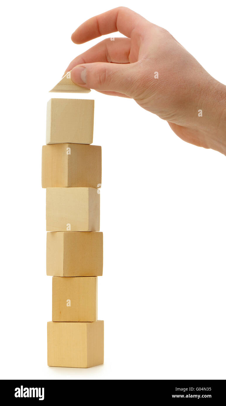 The hand establishes a toy roof on wooden cubes Stock Photo - Alamy