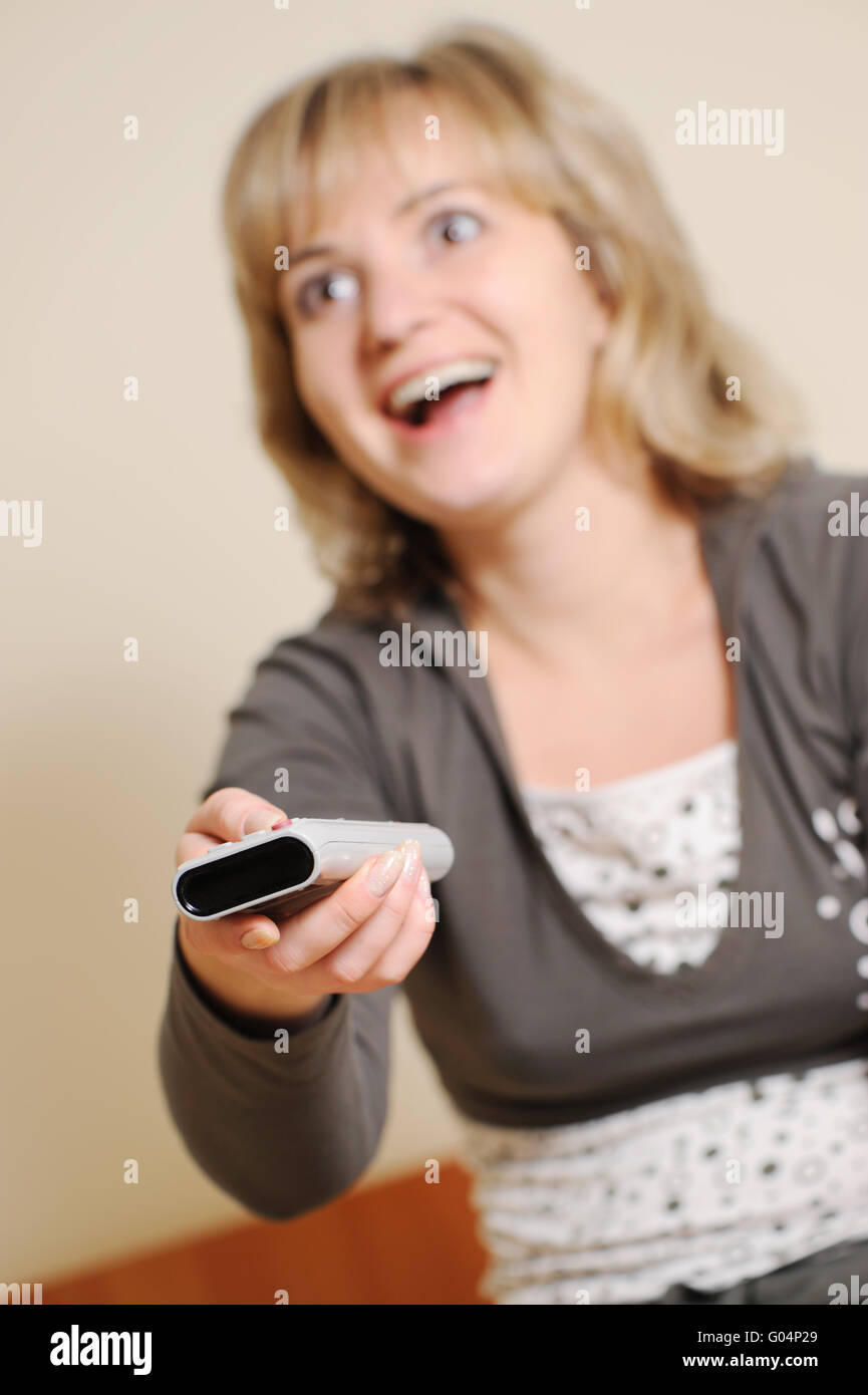 The woman with a television control panel. Selective focus Stock Photo ...