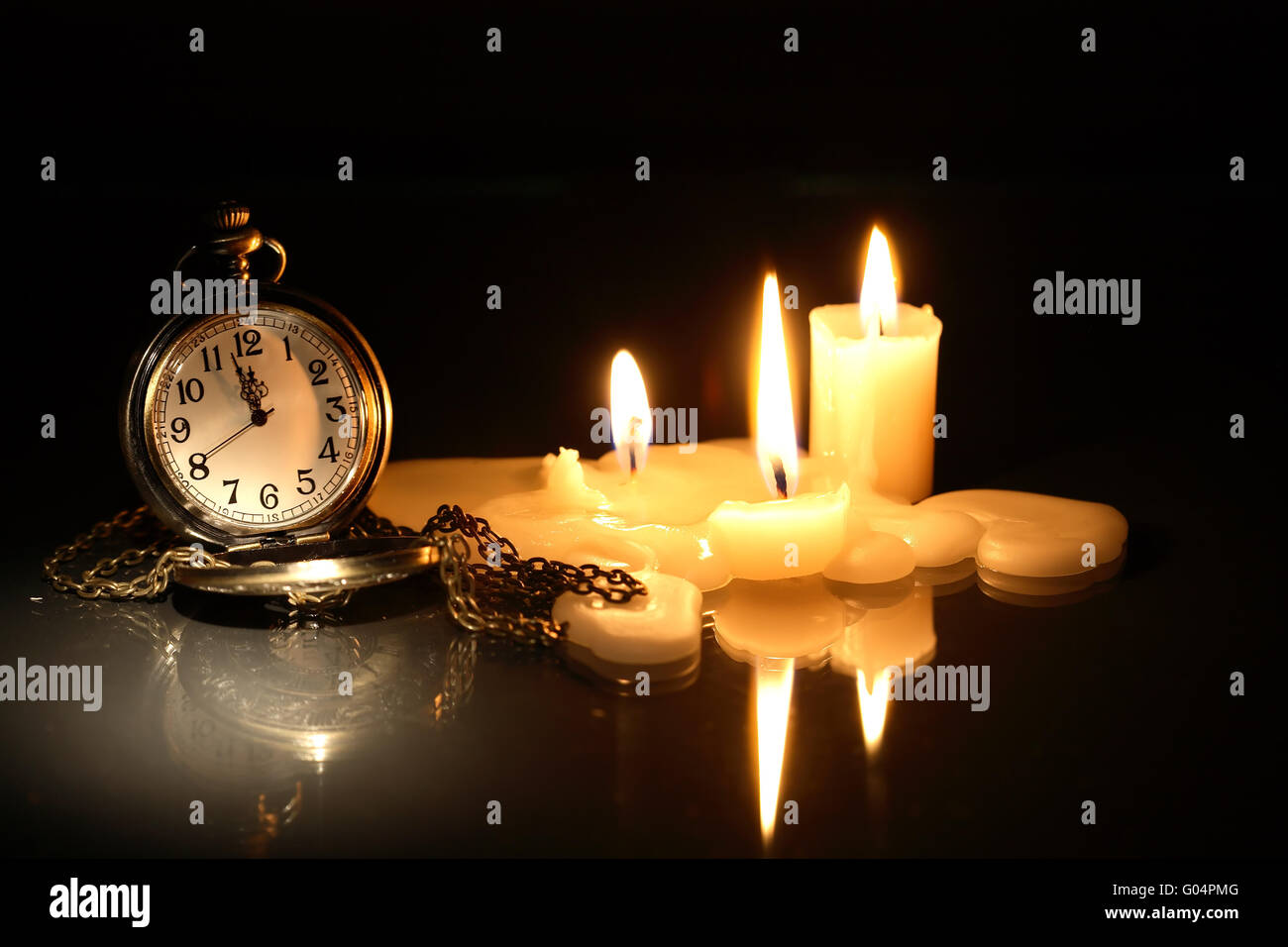 Vintage pocket watch near few lighting candles on dark background Stock ...