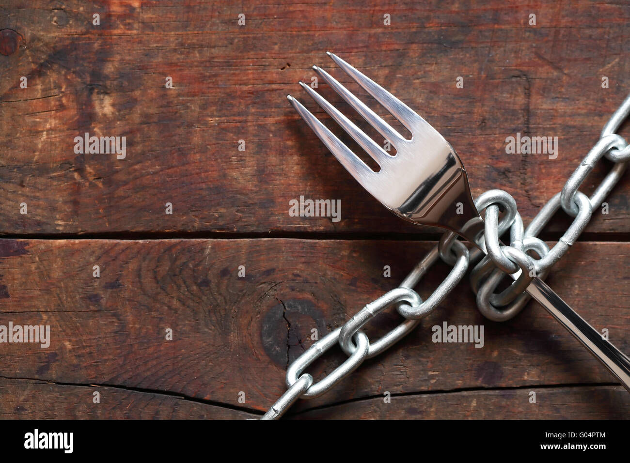 Fork attached with metal chain on wooden background Stock Photo - Alamy