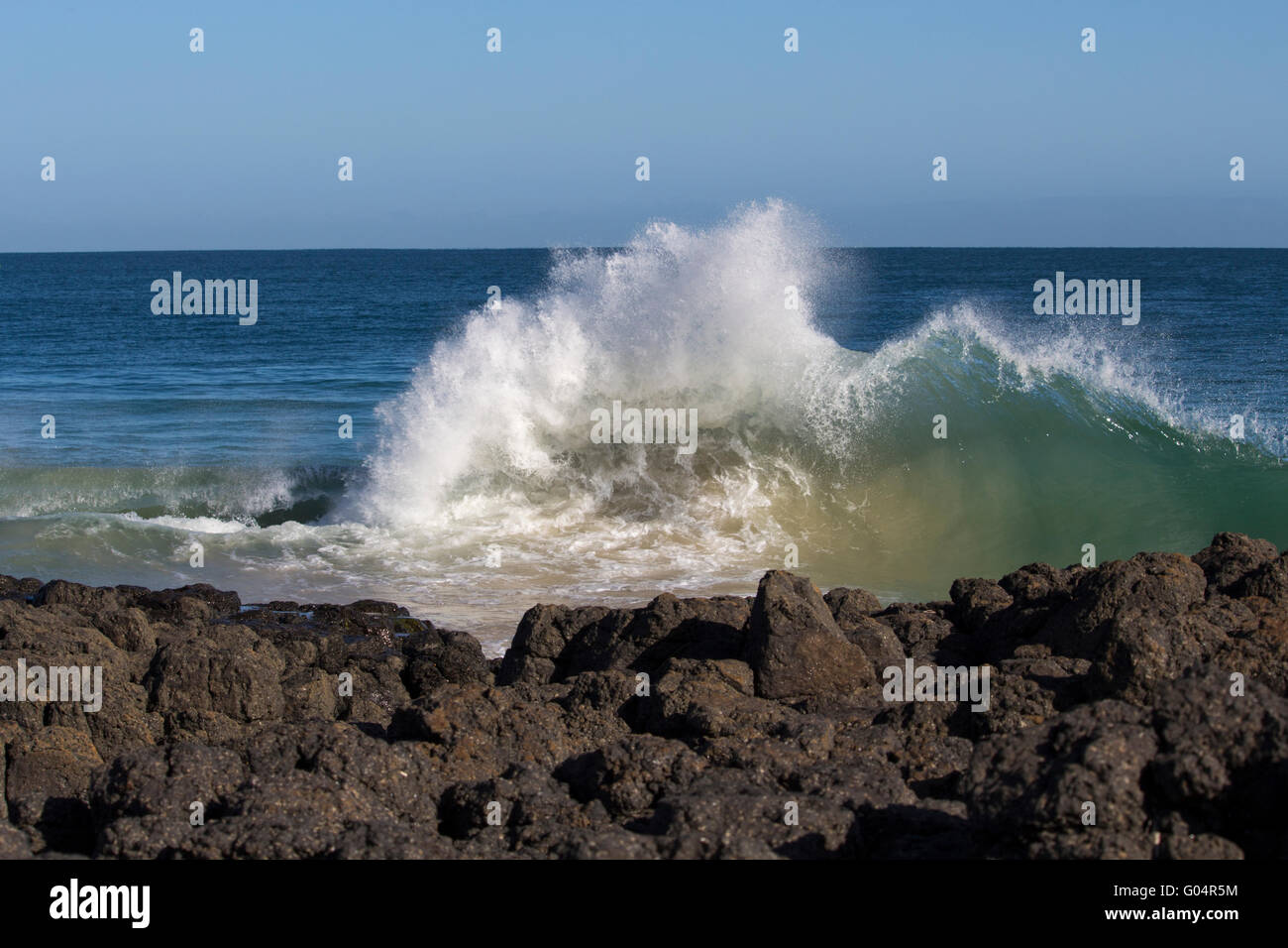 Backwash from high Indian Ocean waves breaking on the dark basalt rocks ...