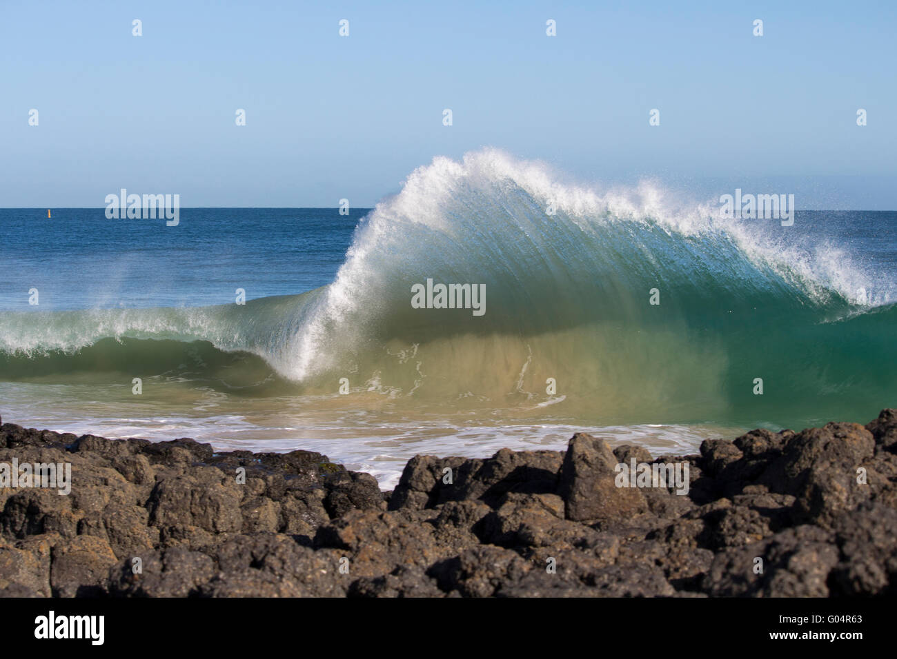 Backwash from high Indian Ocean waves breaking on the dark basalt rocks ...