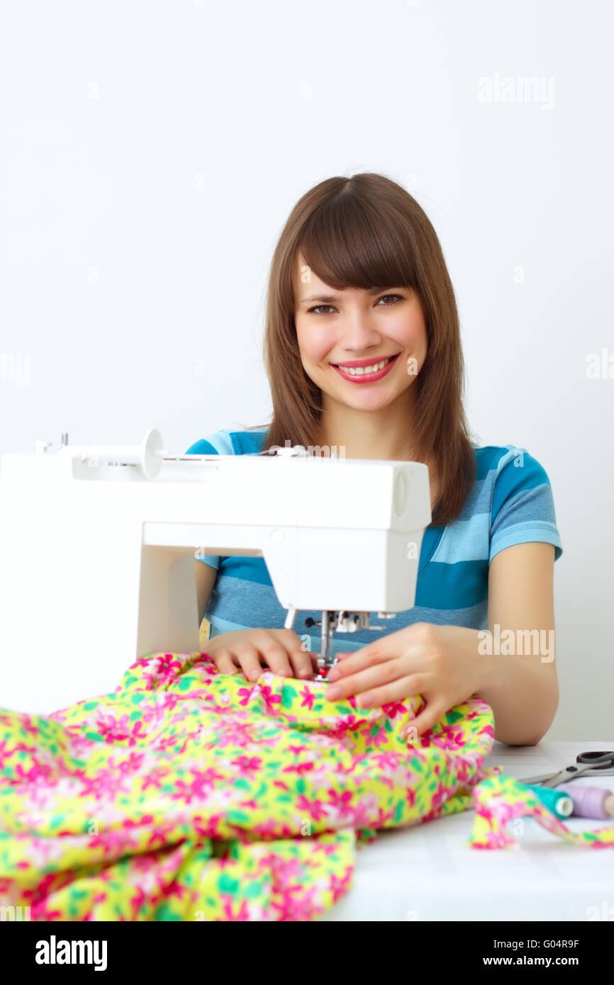 Girl and a sewing machine on a light background Stock Photo - Alamy