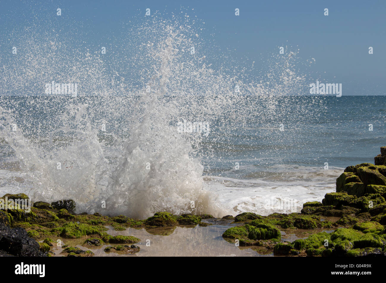 Backwash from high Indian Ocean waves breaking on the dark basalt rocks ...