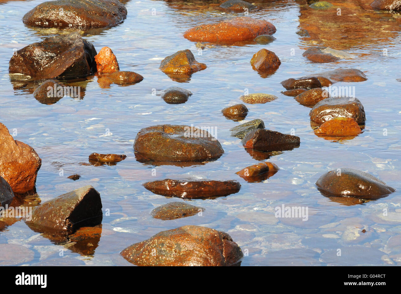 Stones in shallow water Stock Photo - Alamy
