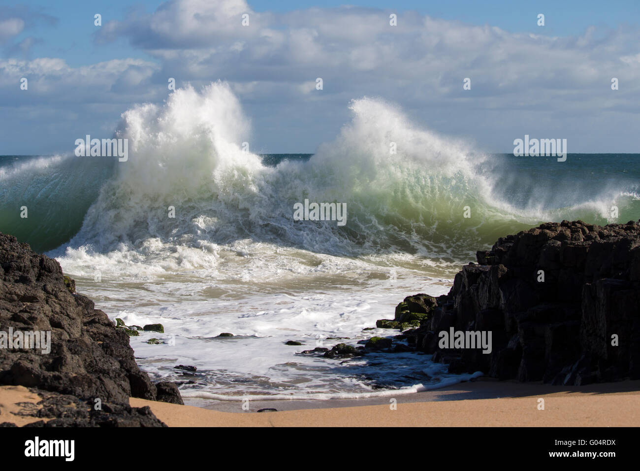 Backwash from high Indian Ocean waves breaking on the dark basalt rocks ...