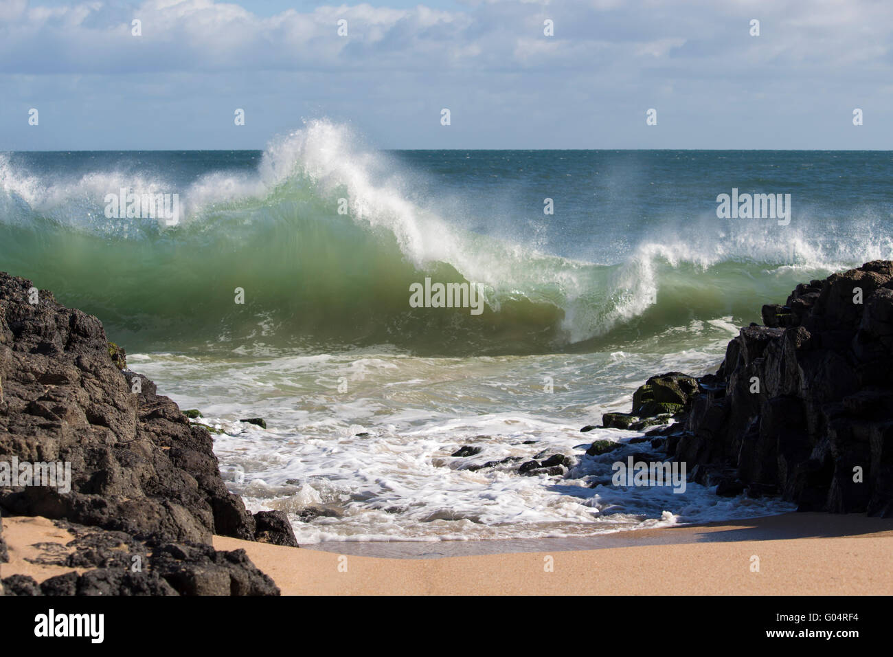 Backwash from high Indian Ocean waves breaking on the dark basalt rocks ...