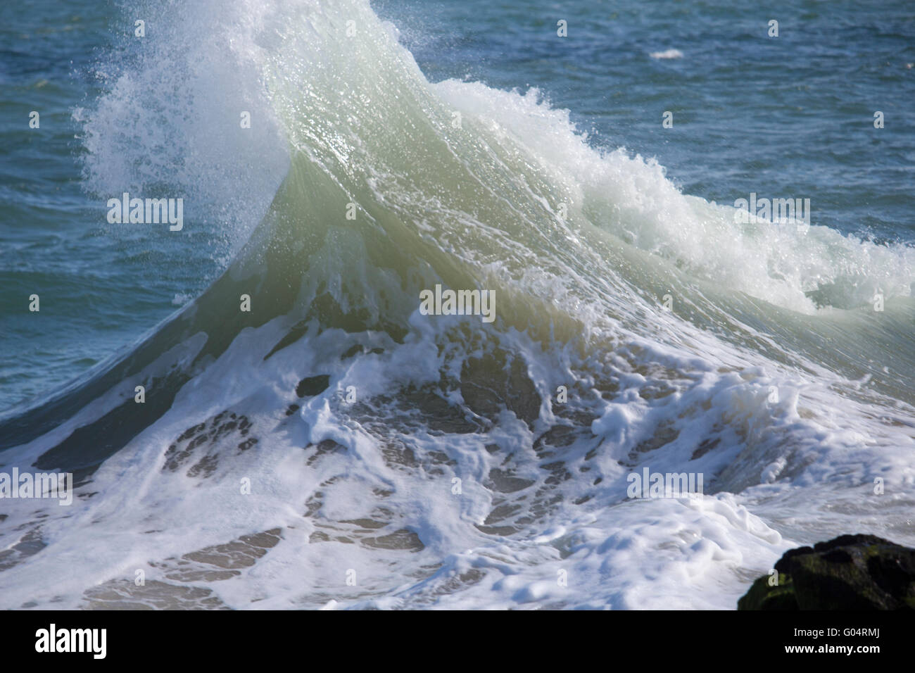 Backwash from high Indian Ocean waves breaking on the dark basalt rocks ...
