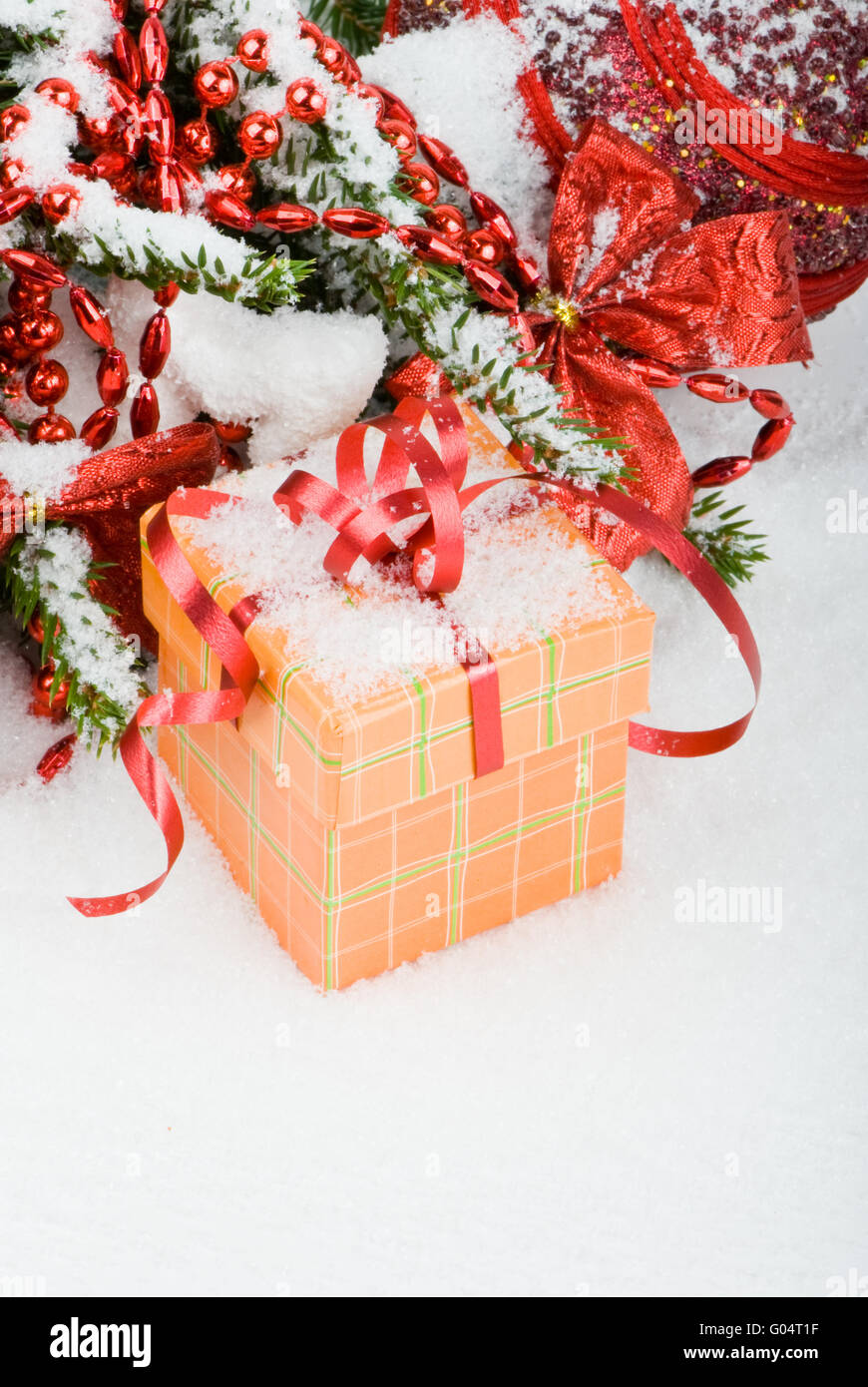 Christmas tree in the snow with red balls and gift box Stock Photo - Alamy