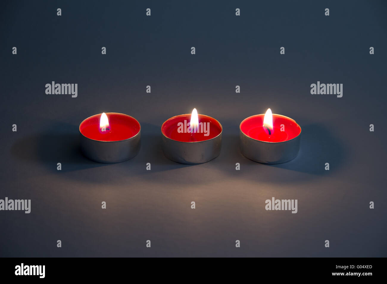 three candles in a line Stock Photo - Alamy