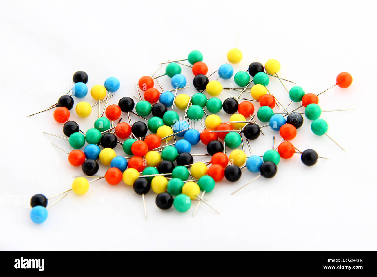 different colored pins on a white background Stock Photo - Alamy