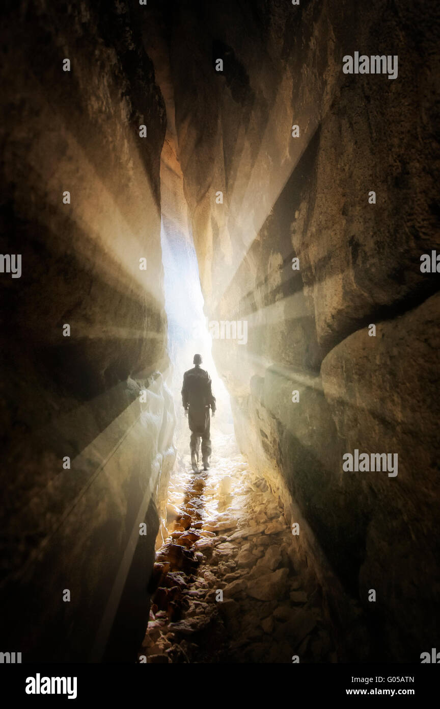 man exploring dark cave Stock Photo - Alamy