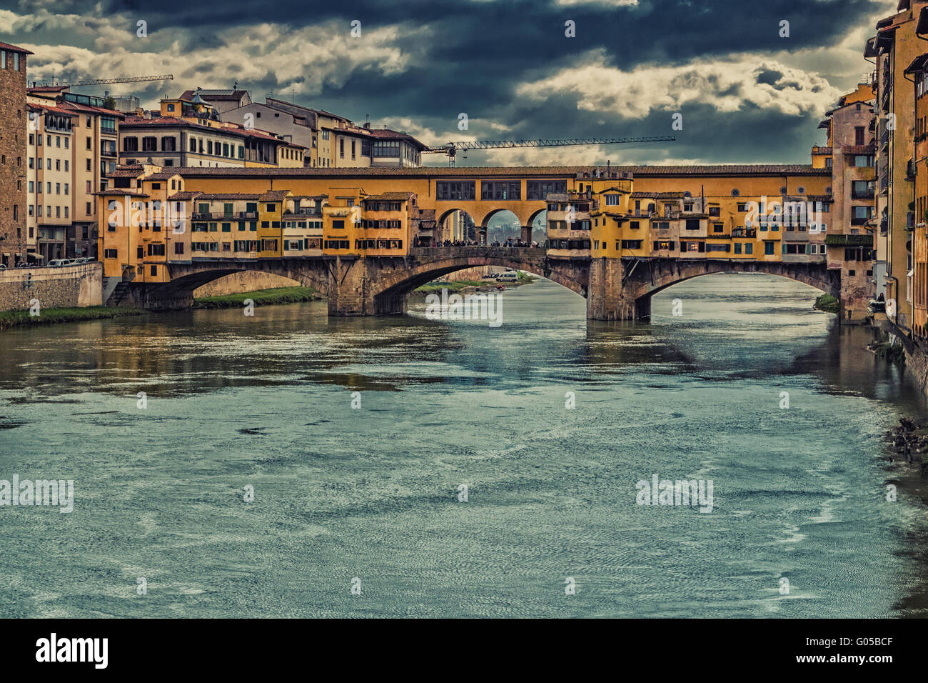 historic buildings overlooking the Arno river that flows peacefully ...