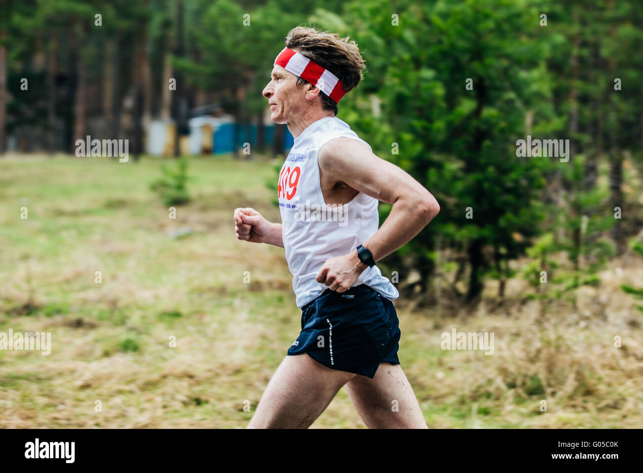 single man middle-aged runner in Park during Half marathon in woods ...