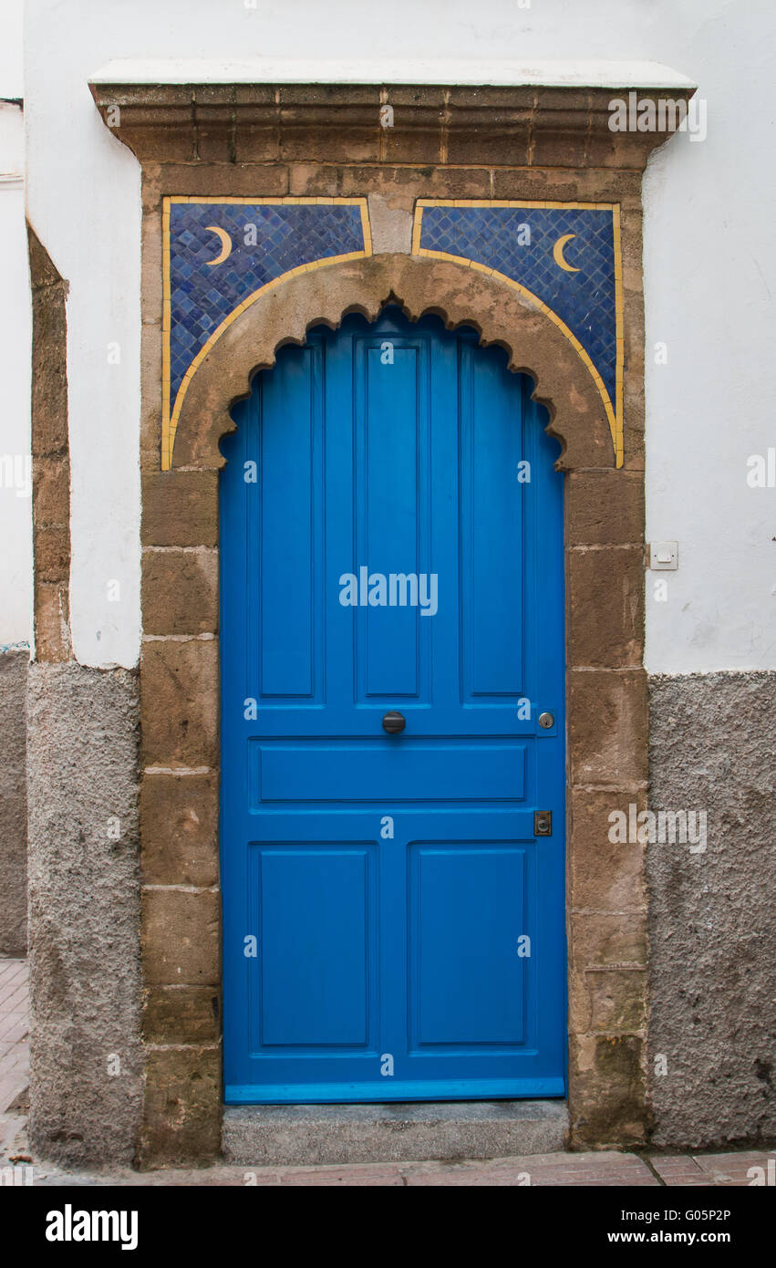 Bright blue color of the gate. Frame with an arch made of stone. Two ...