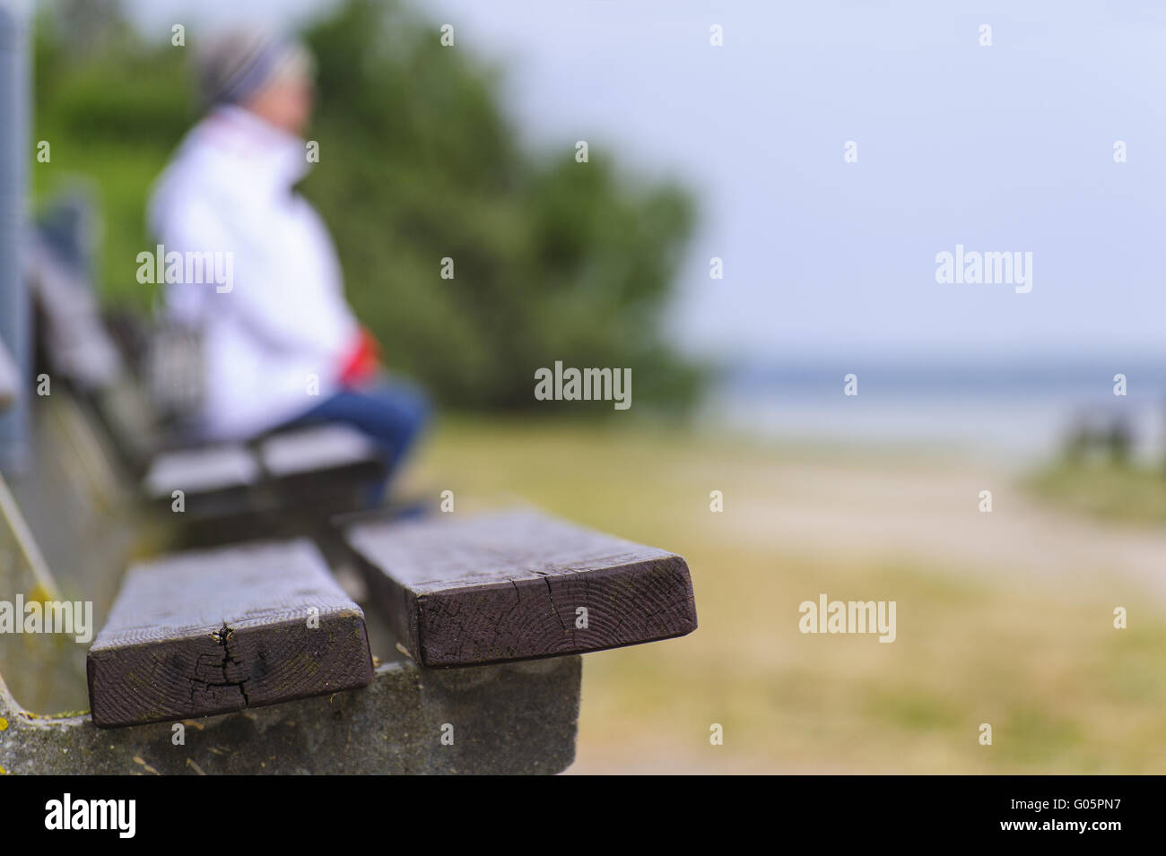 a woman sitting alone on a bench on the Baltic coa Stock Photo - Alamy