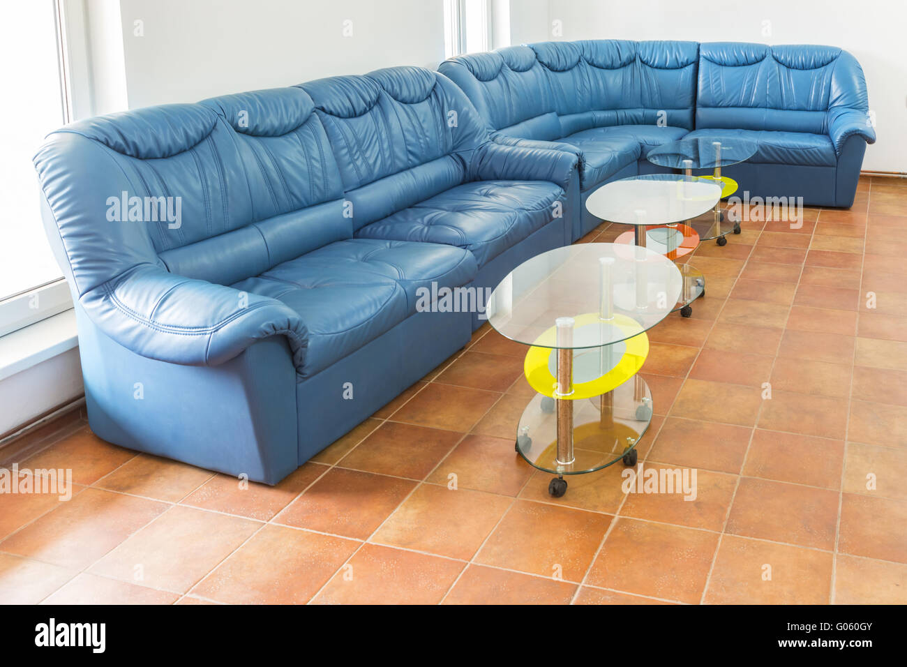 Empty waiting room with a big blue sofa and two small tables Stock ...