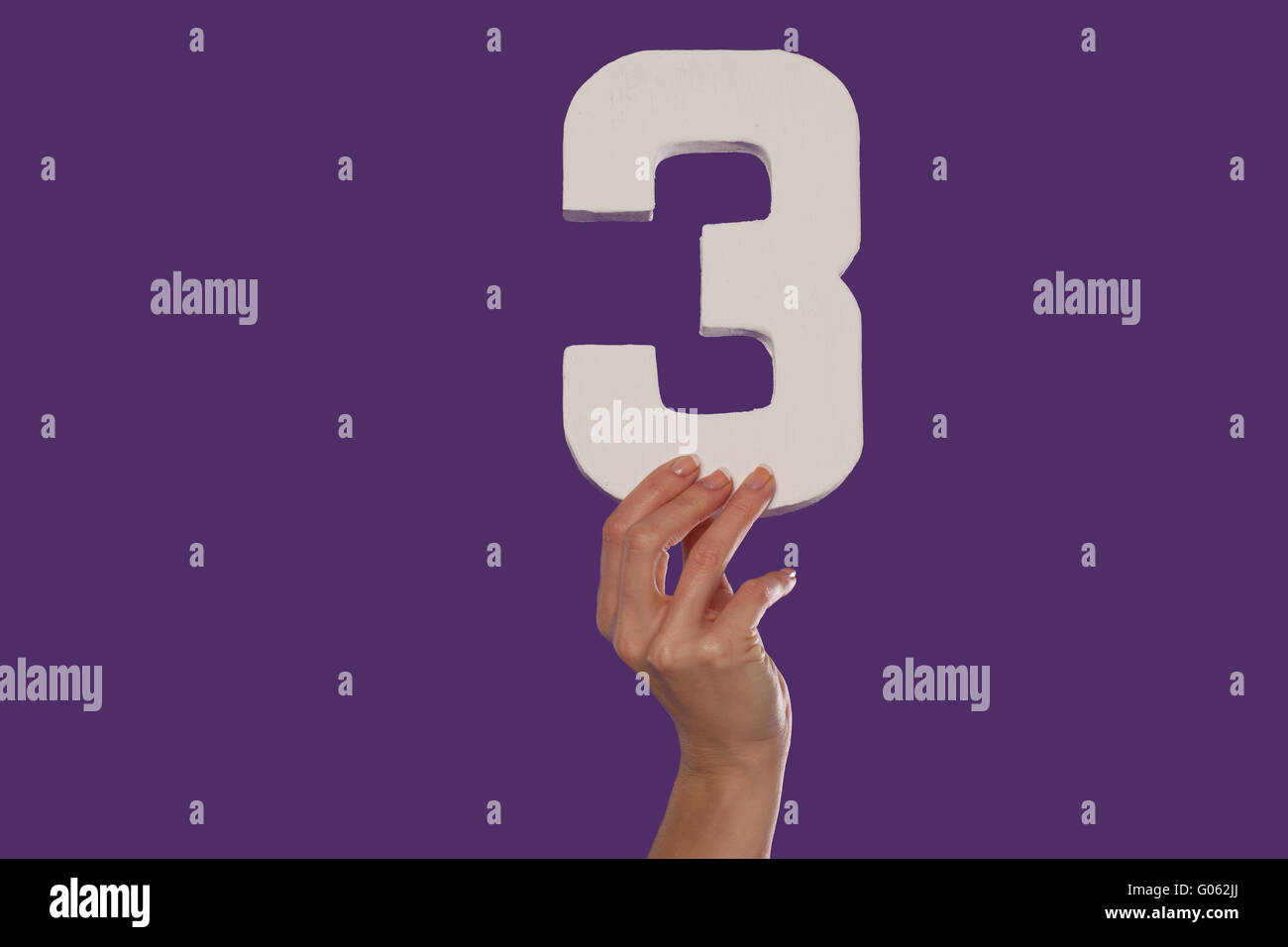 Female hand holding the number 3 from the bottom Stock Photo - Alamy