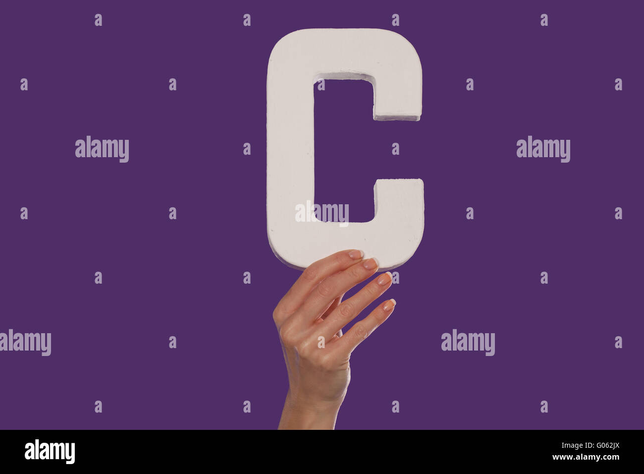 Female hand holding the letter C from the bottom Stock Photo - Alamy
