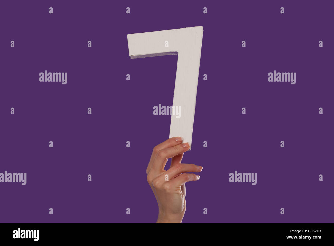 Female hand holding the number 7 from the bottom Stock Photo - Alamy